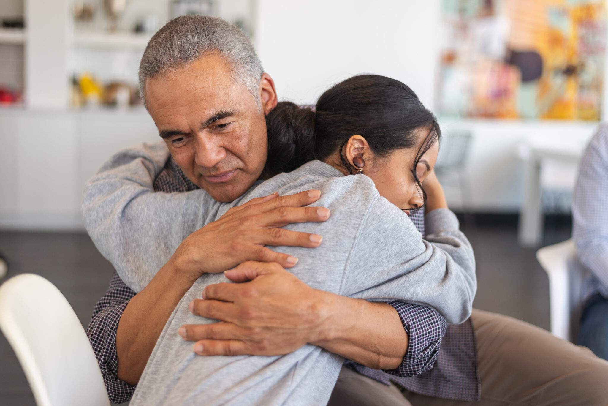 Father gives daughter a supportive hug in a group therapy session - KVC ...